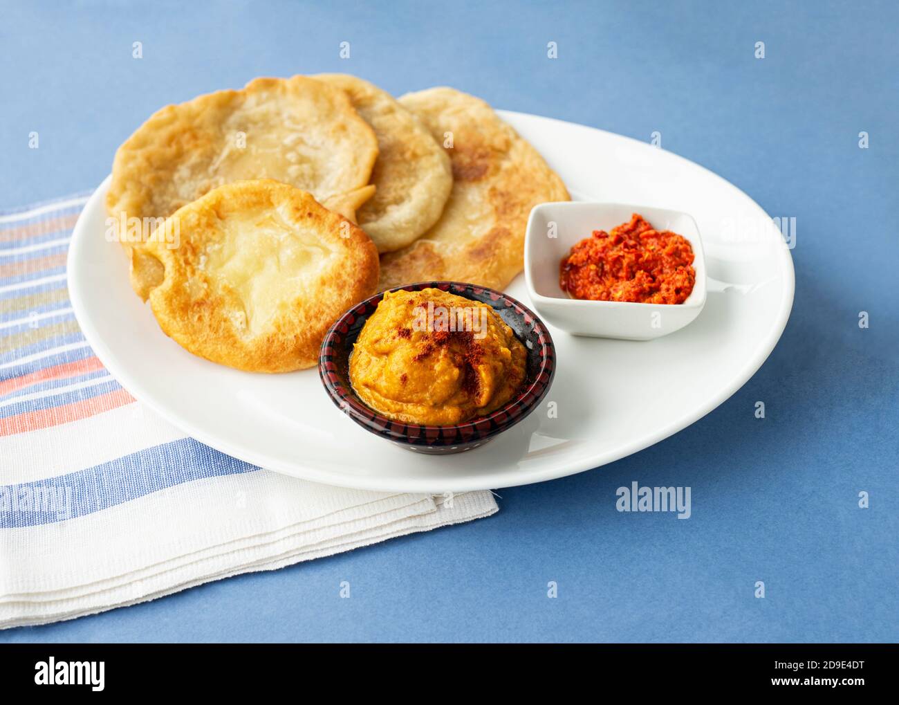 Indian fried puri tortillas with vegetable tapas on a white oval plate ...