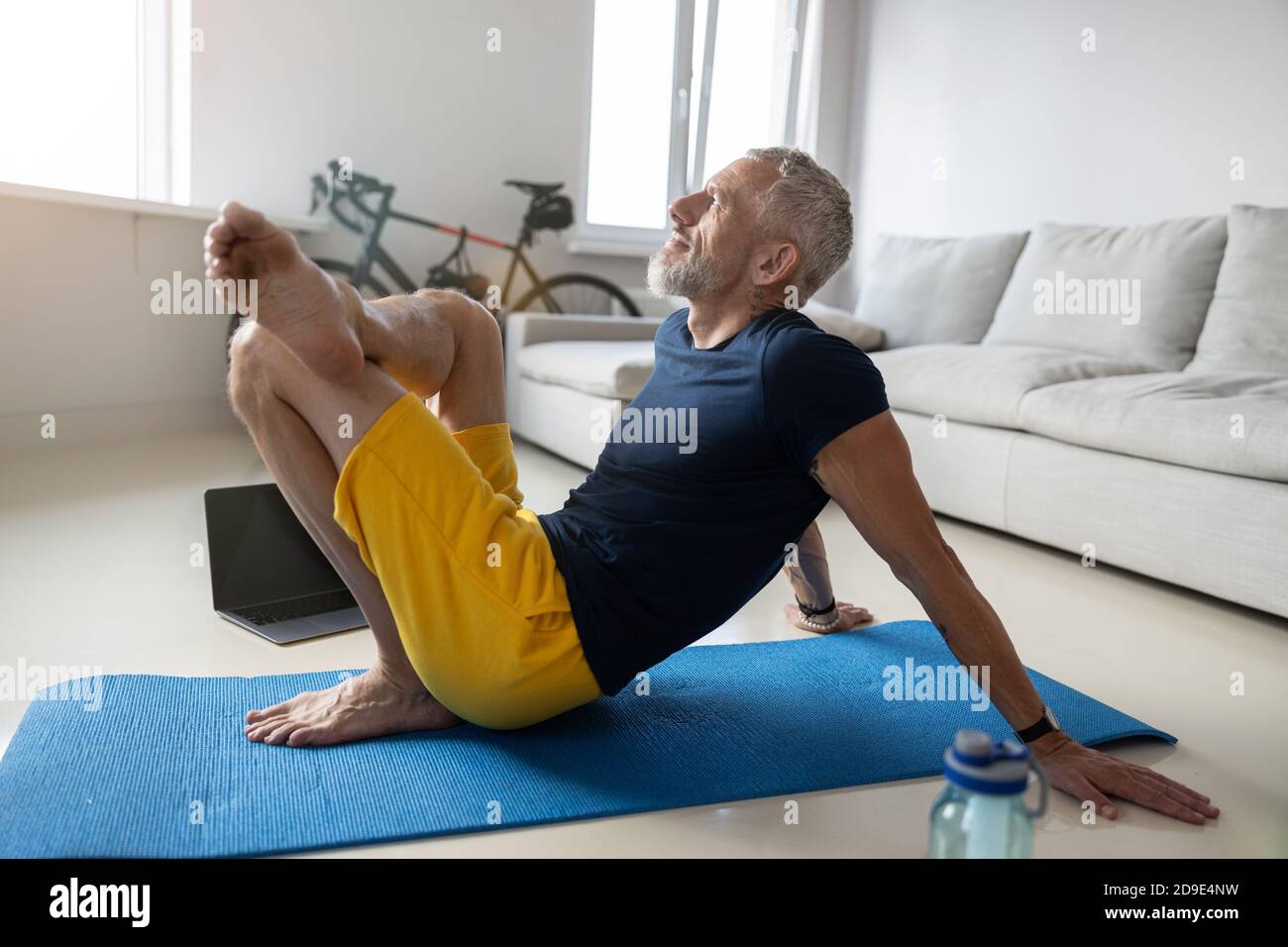 Athletic male throwing right leg on a left Stock Photo - Alamy