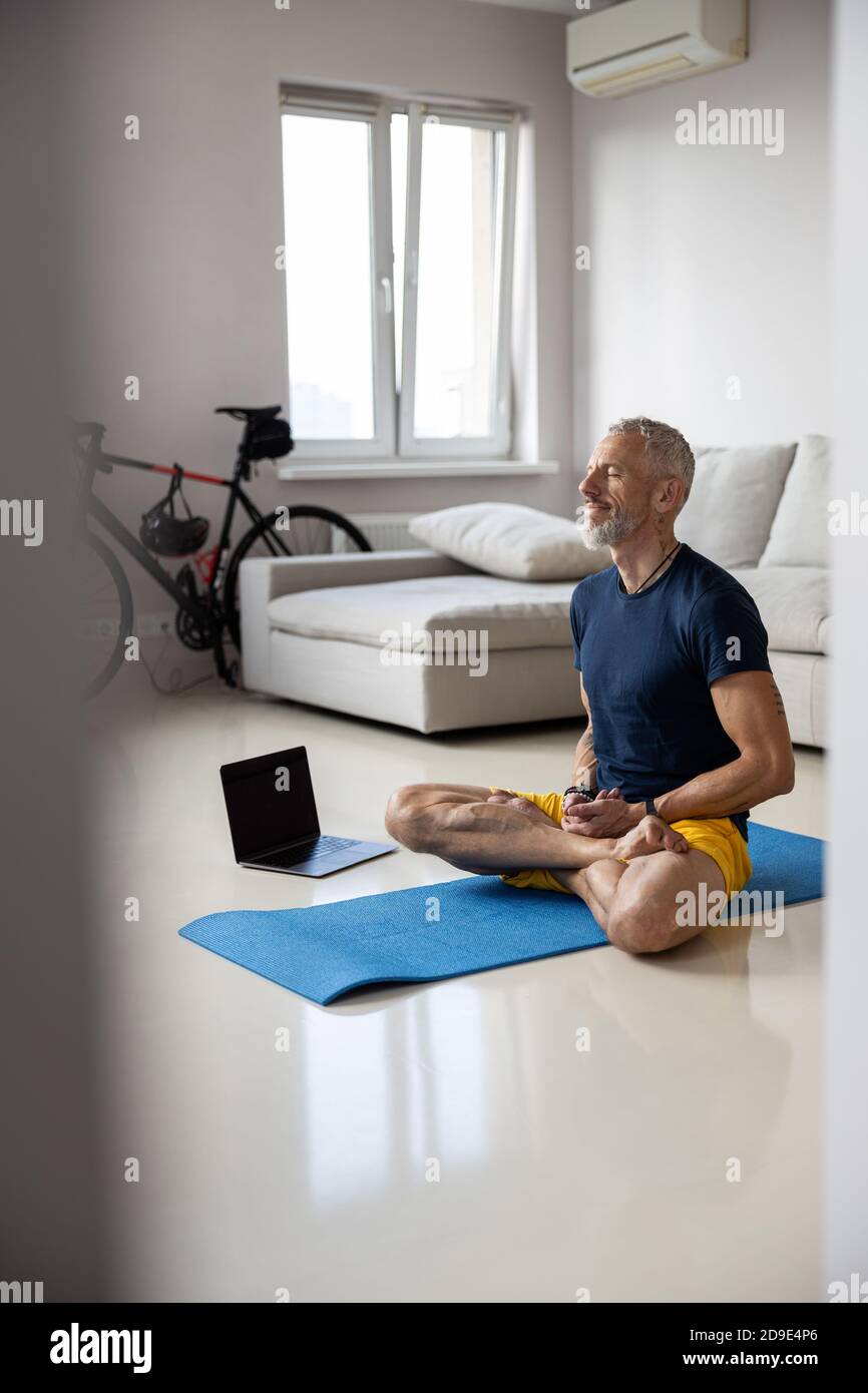 Muscular male meditating on a small mat Stock Photo - Alamy