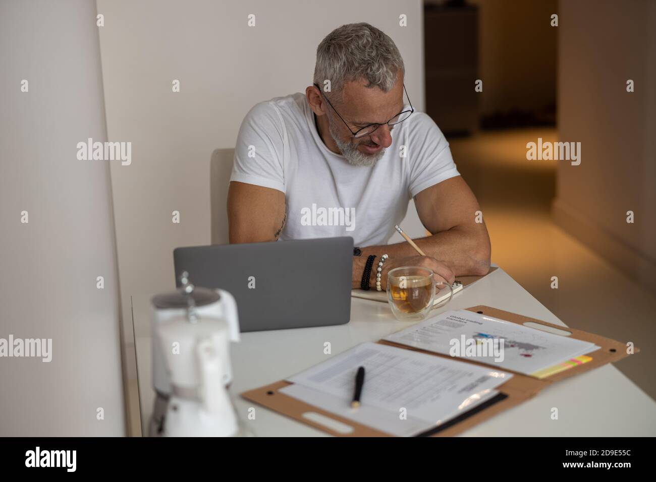 Inspired manager is writing in his notepad Stock Photo - Alamy