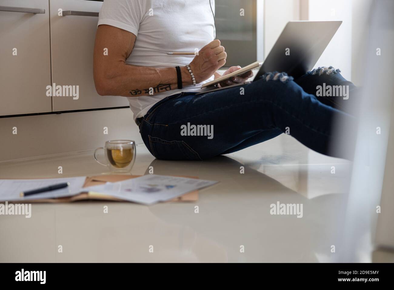 Man taking down notes while being on a floor Stock Photo - Alamy