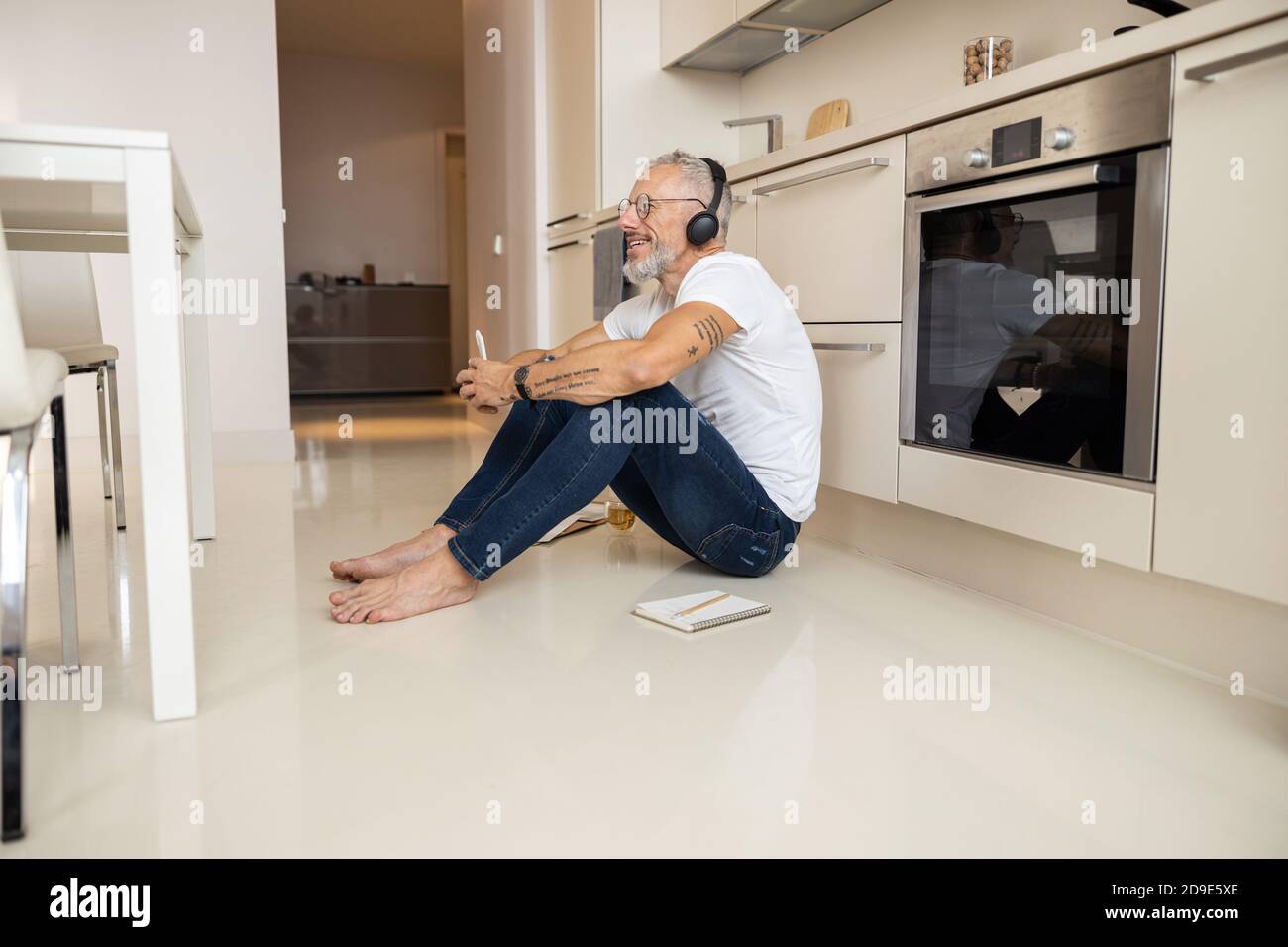 Dreamy male wrapping his hands around the knees Stock Photo - Alamy