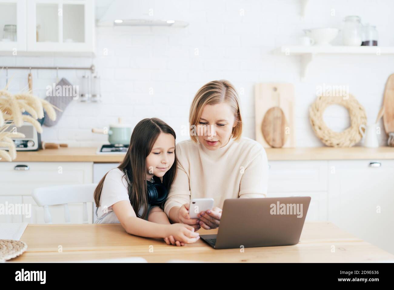Mom and her teenage daughter look at the phone Stock Photo - Alamy