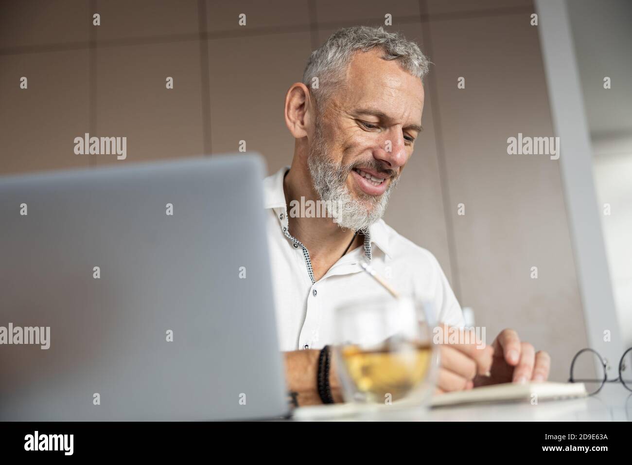 Relaxed male starting his writing in a pad Stock Photo - Alamy