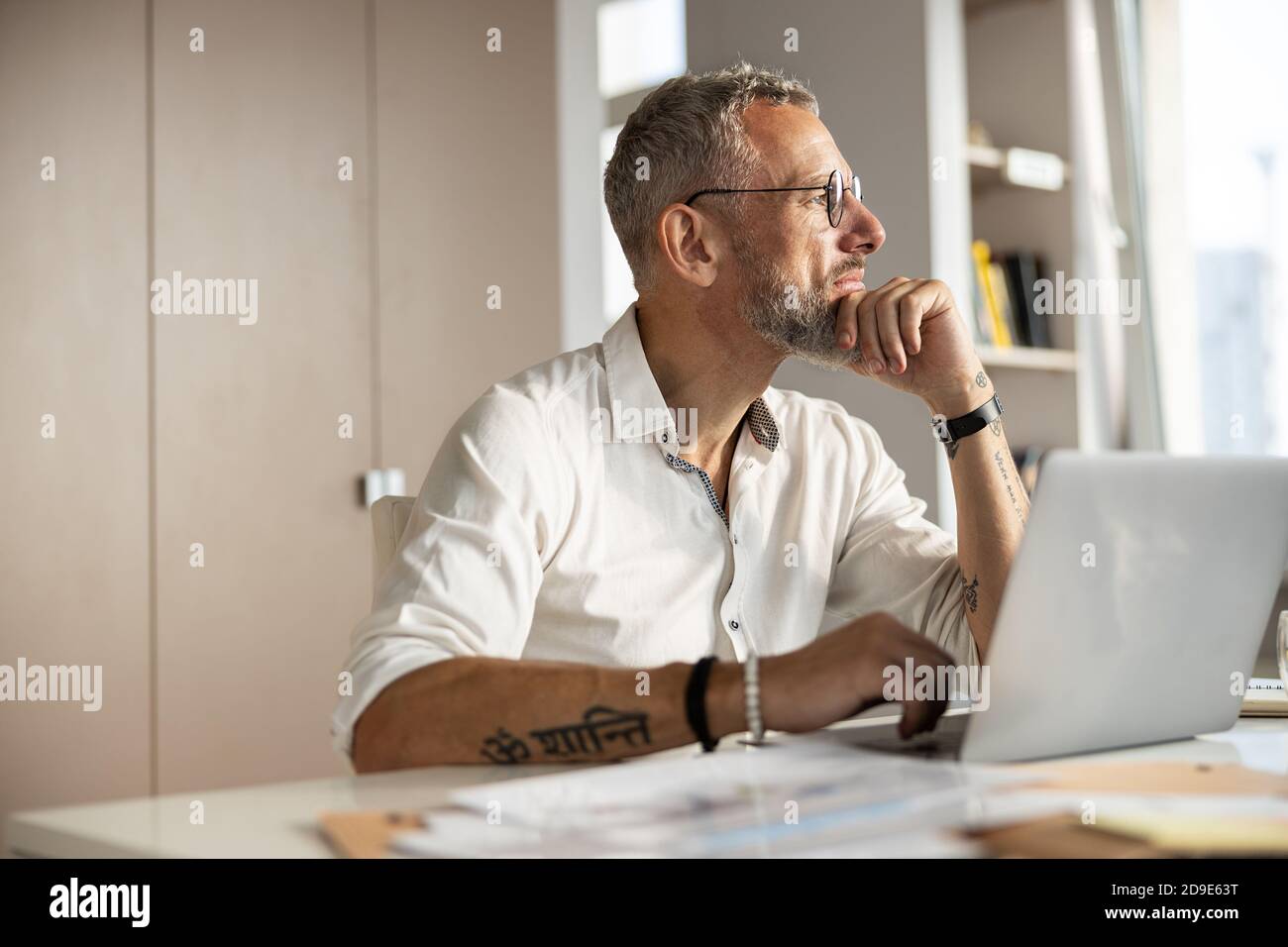 Thoughtful entrepreneur is staring in the window Stock Photo - Alamy
