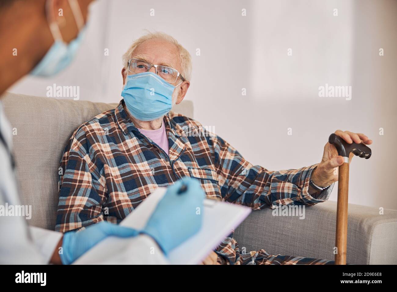 Geriatrician taking notes of the condition of an elderly man Stock ...