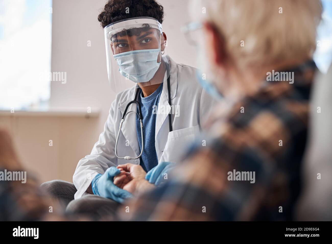 Young geriatric physician conducting a medical check-up Stock Photo - Alamy