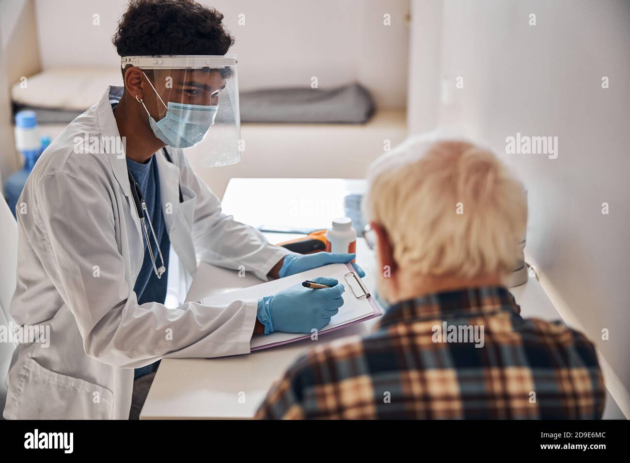Healthcare professional with a clipboard staring at his patient Stock ...