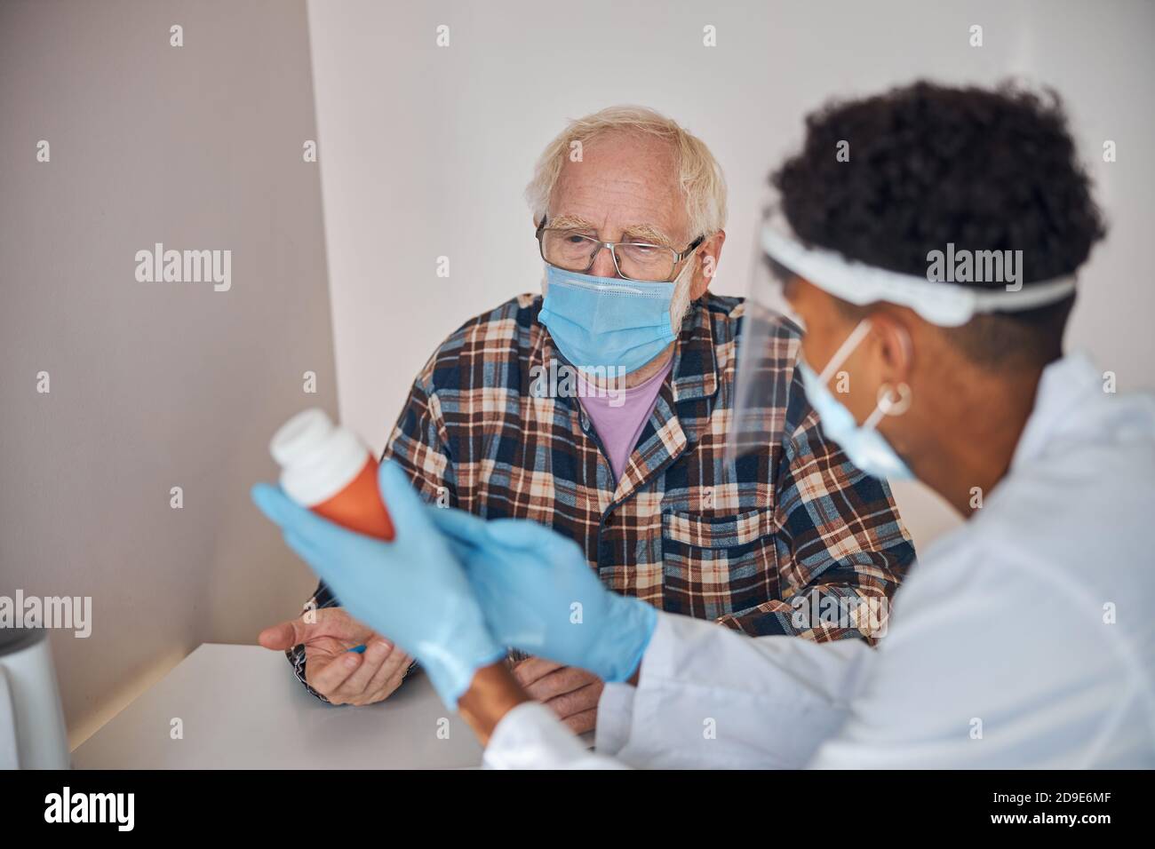 Geriatric physician prescribing multivitamins to a senior man Stock ...