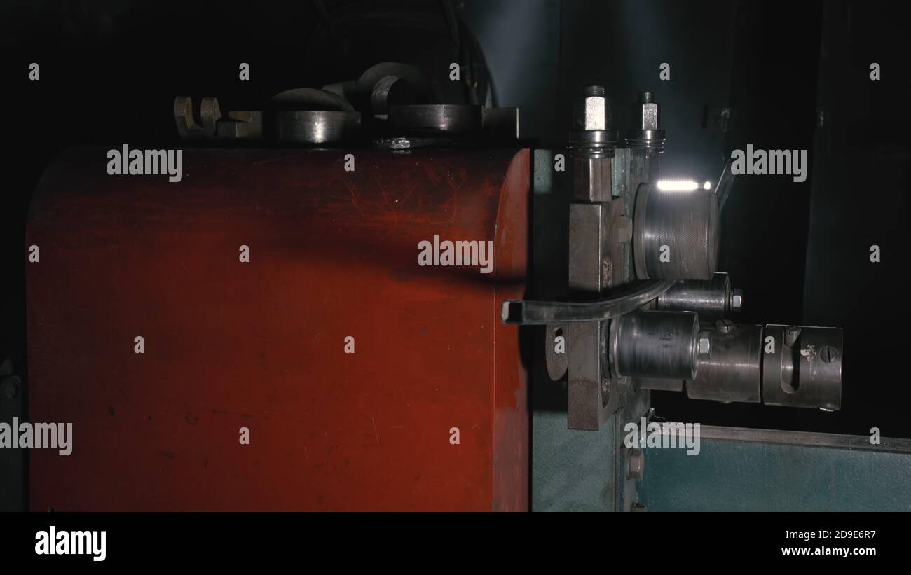 Forge workshop on table. Worker bends the metal rod on the wrought iron ...