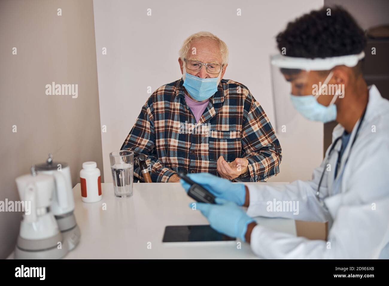 Senior patient staring at the doctor with a glucose meter Stock Photo ...