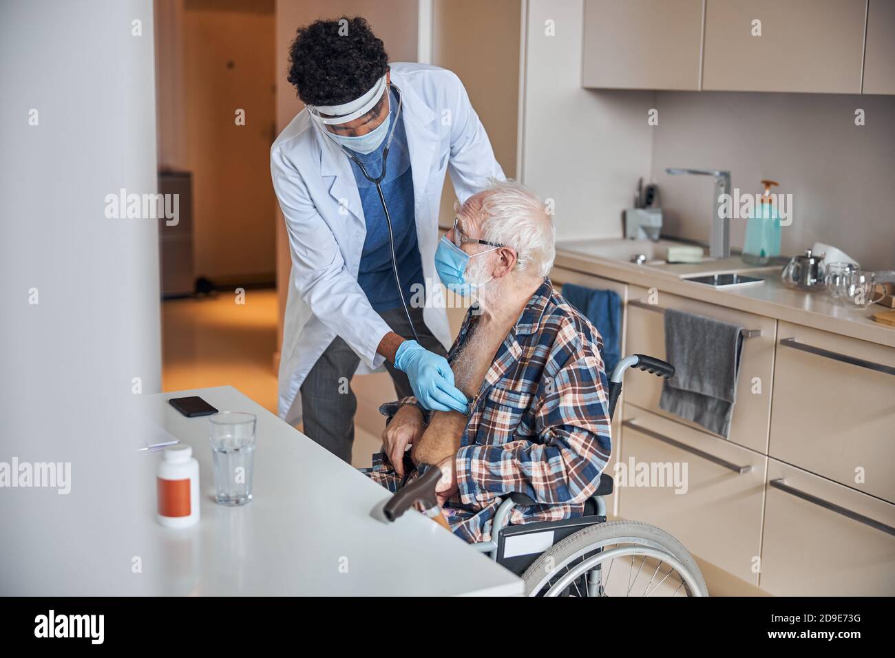 Experienced young doctor performing the cardiac auscultation Stock ...