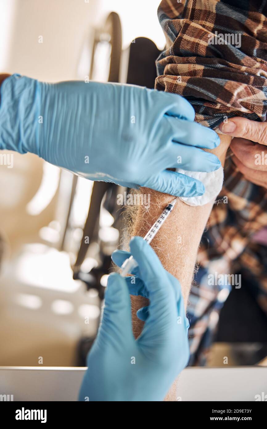 Healthcare professional giving an injection to a patient Stock Photo ...