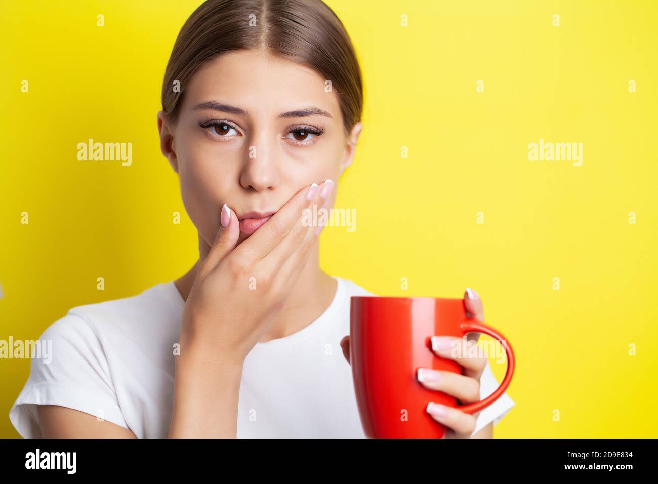 Woman experiencing severe toothache holding her hand over her cheek ...