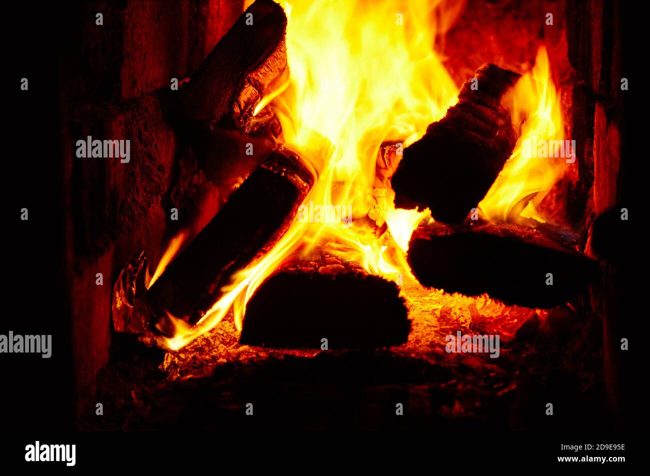 Crest of flame on burning wood in fireplace. Close-up of fire in hot ...
