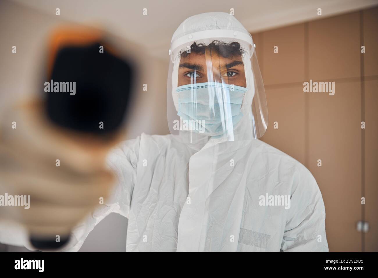 Doctor dressed in a hazmat suit during the temperature measurement ...