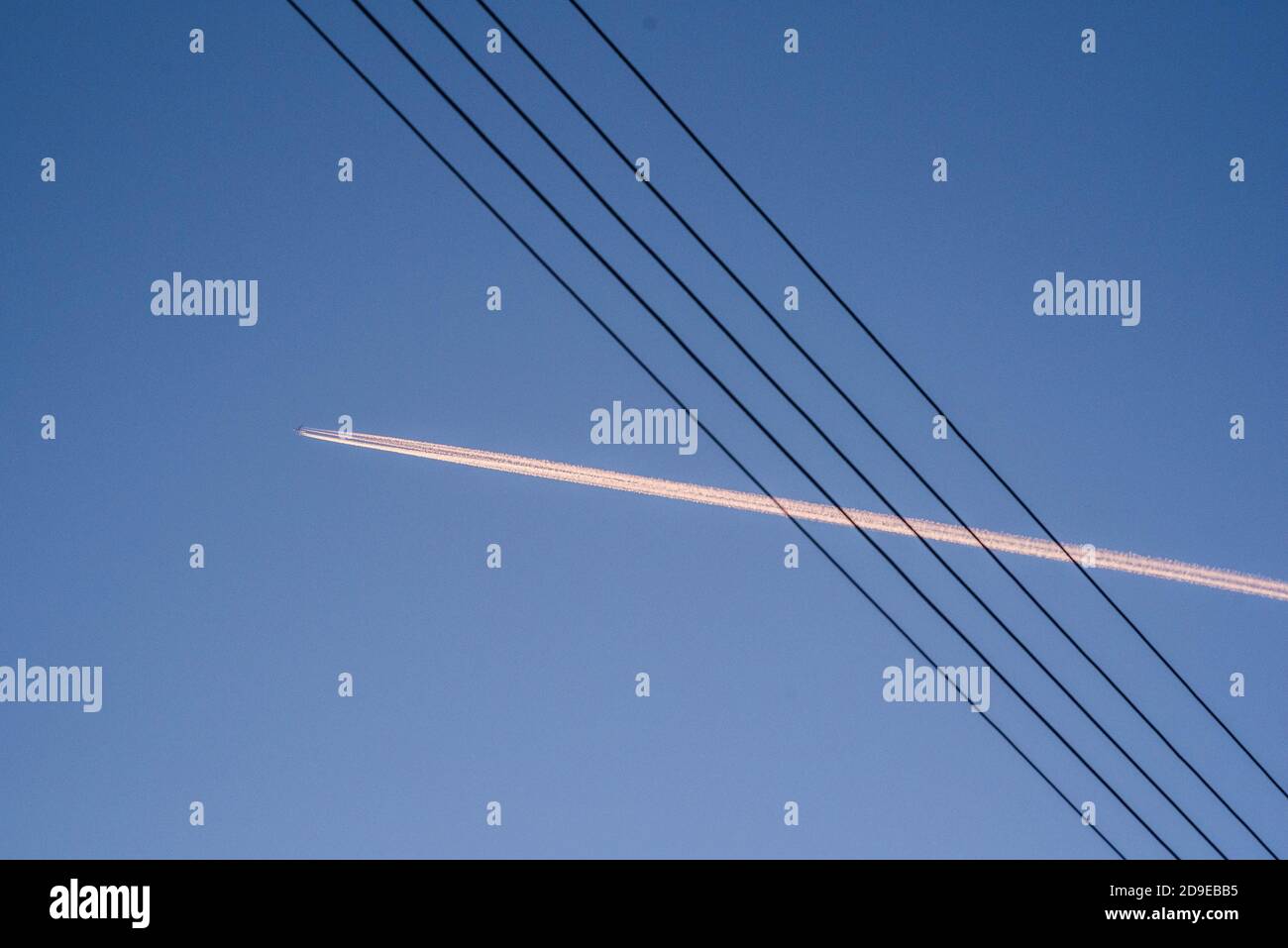 Power lines in the sky and a trail Stock Photo - Alamy