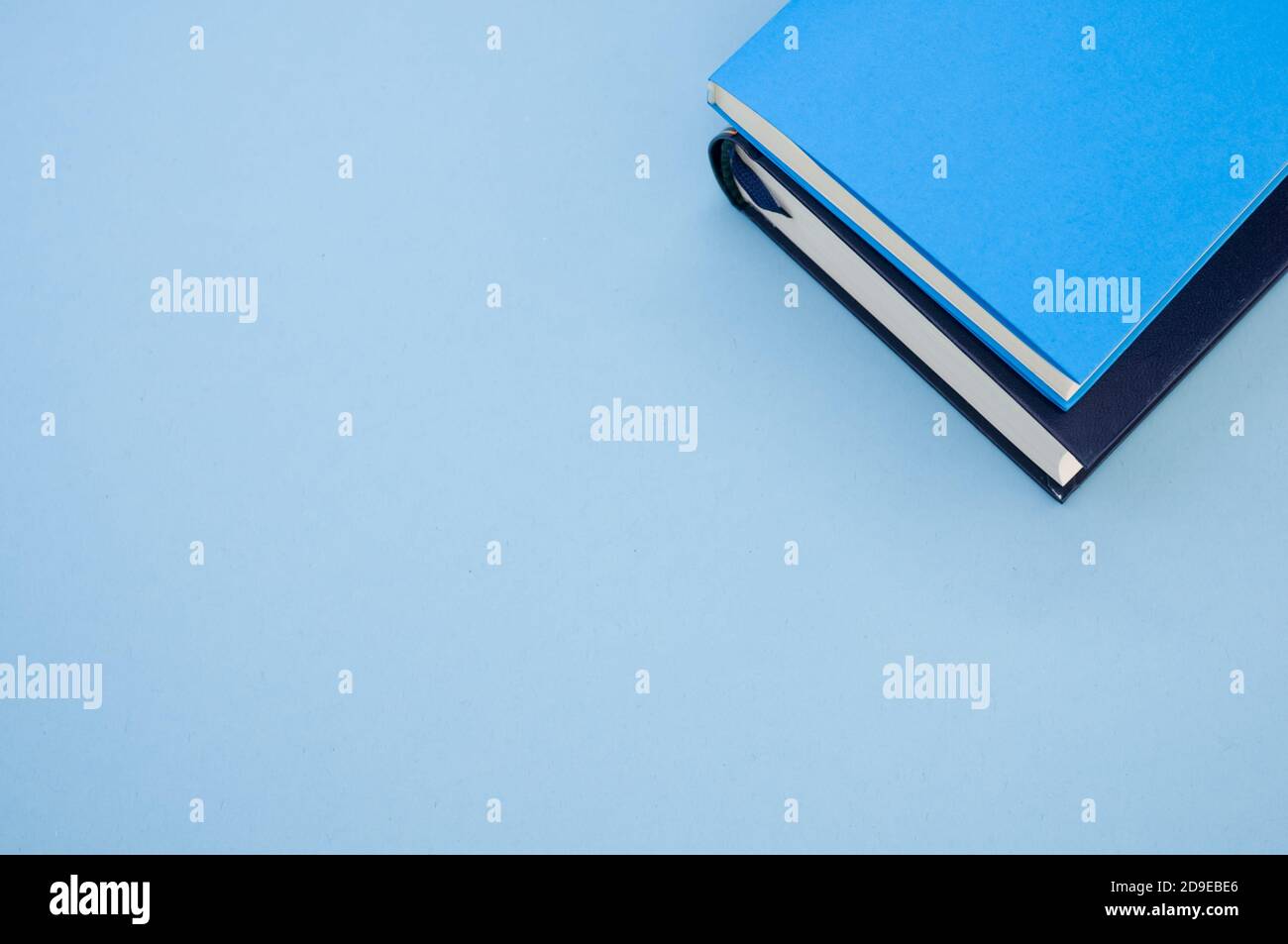 Top view of the hardcover books on the blue surface - space for text ...
