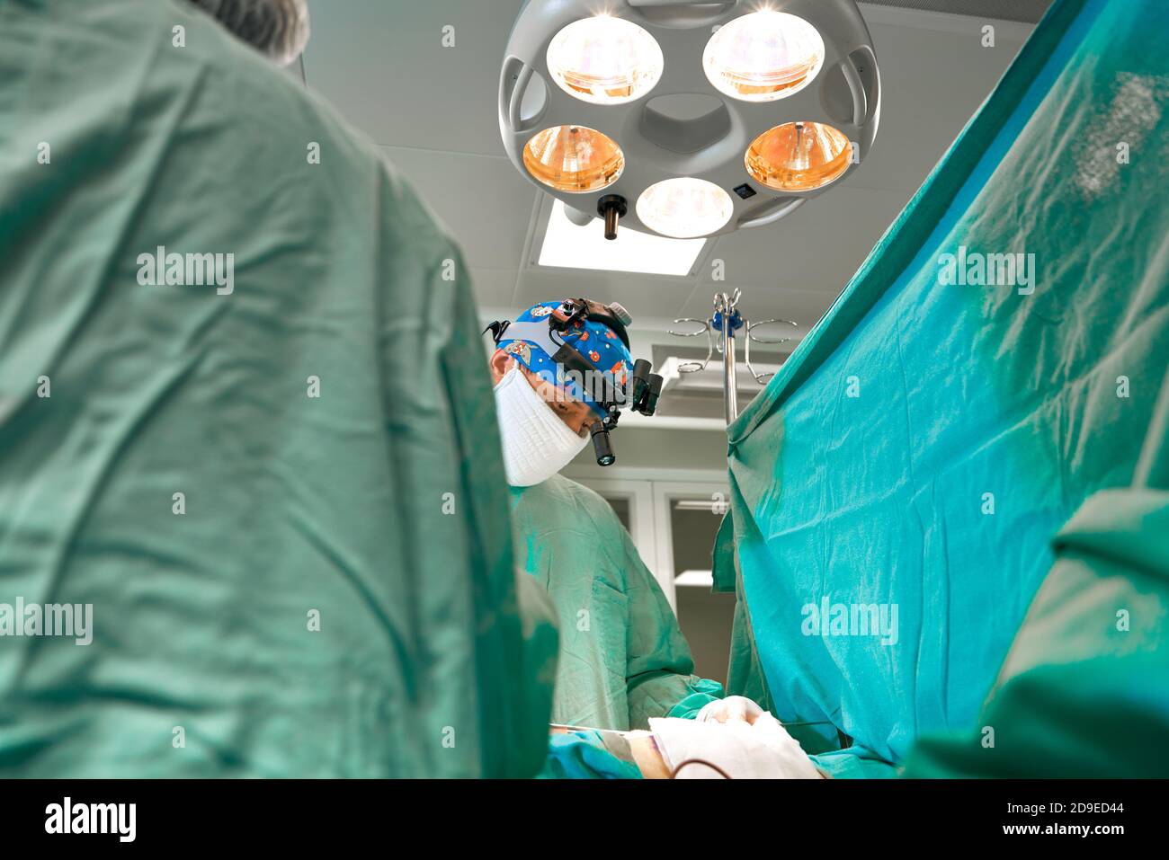 Surgeon and his assistant performing cosmetic surgery on nose in ...