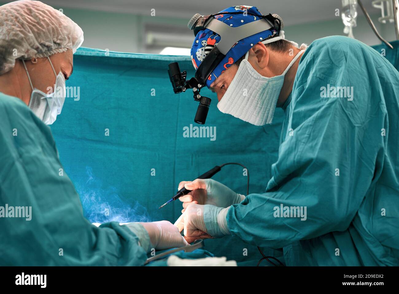 Surgeon and his assistant performing cosmetic surgery on nose in ...