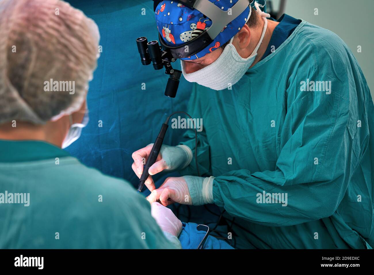 Surgeon and his assistant performing cosmetic surgery on nose in ...