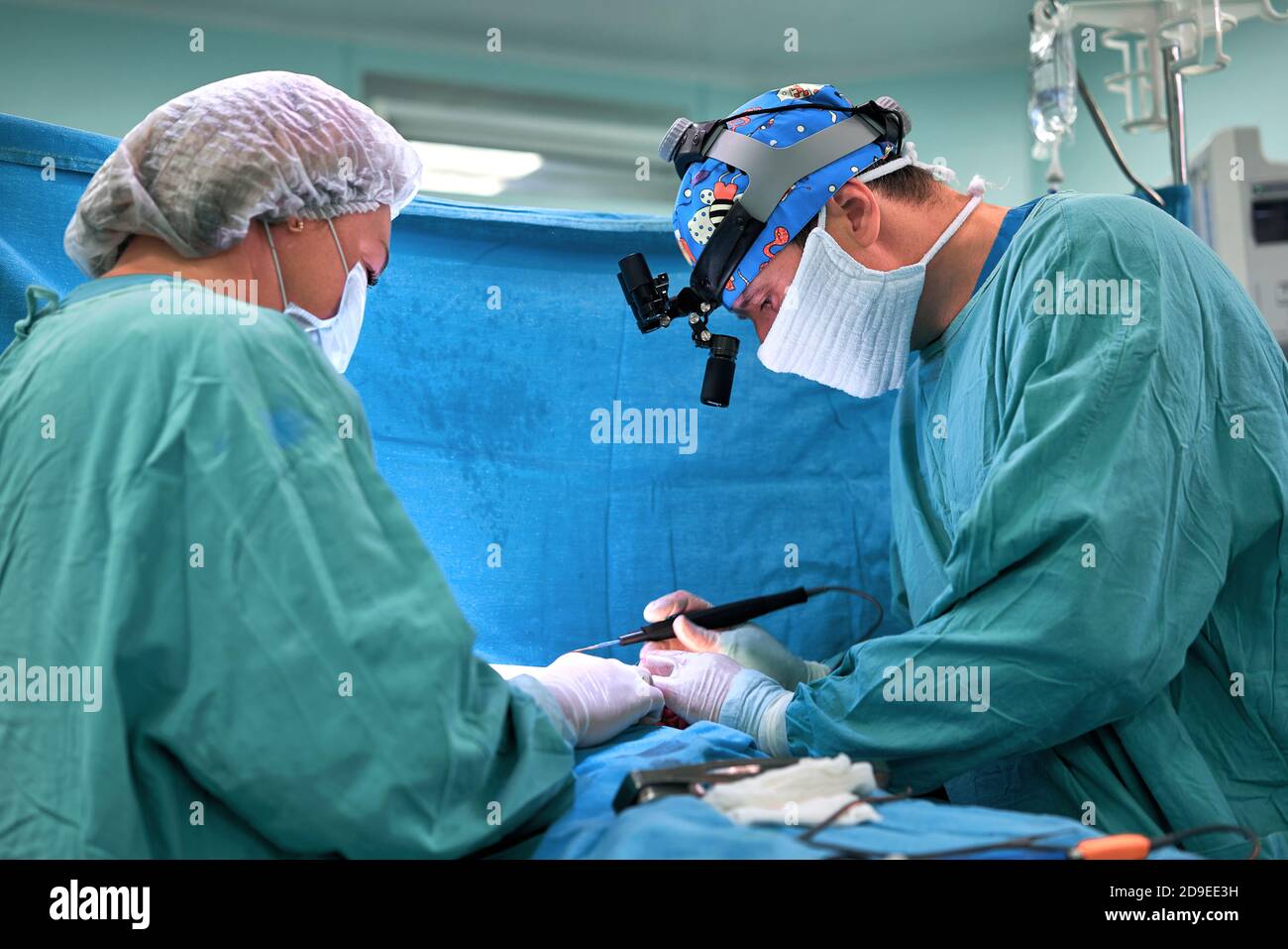 Surgeon and his assistant performing cosmetic surgery on nose in ...