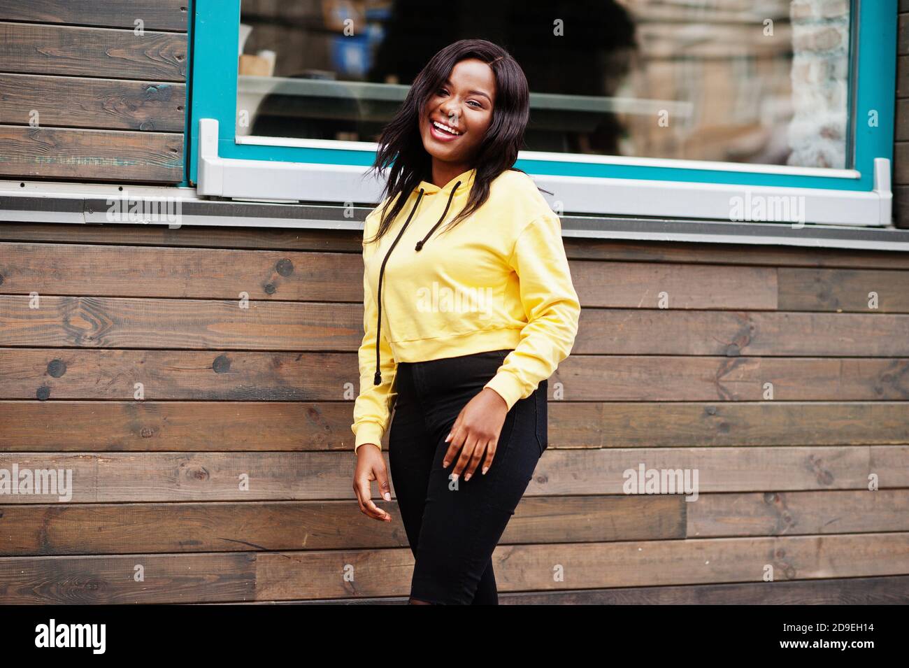Hipster African American Girl Wearing Yellow Hoodie Posing At Street