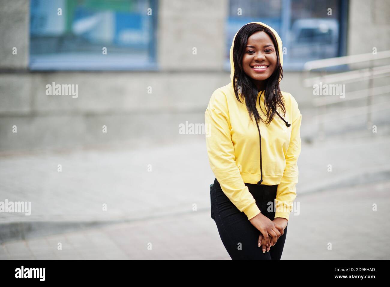 Hipster African American Girl Wearing Yellow Hoodie Posing At Street