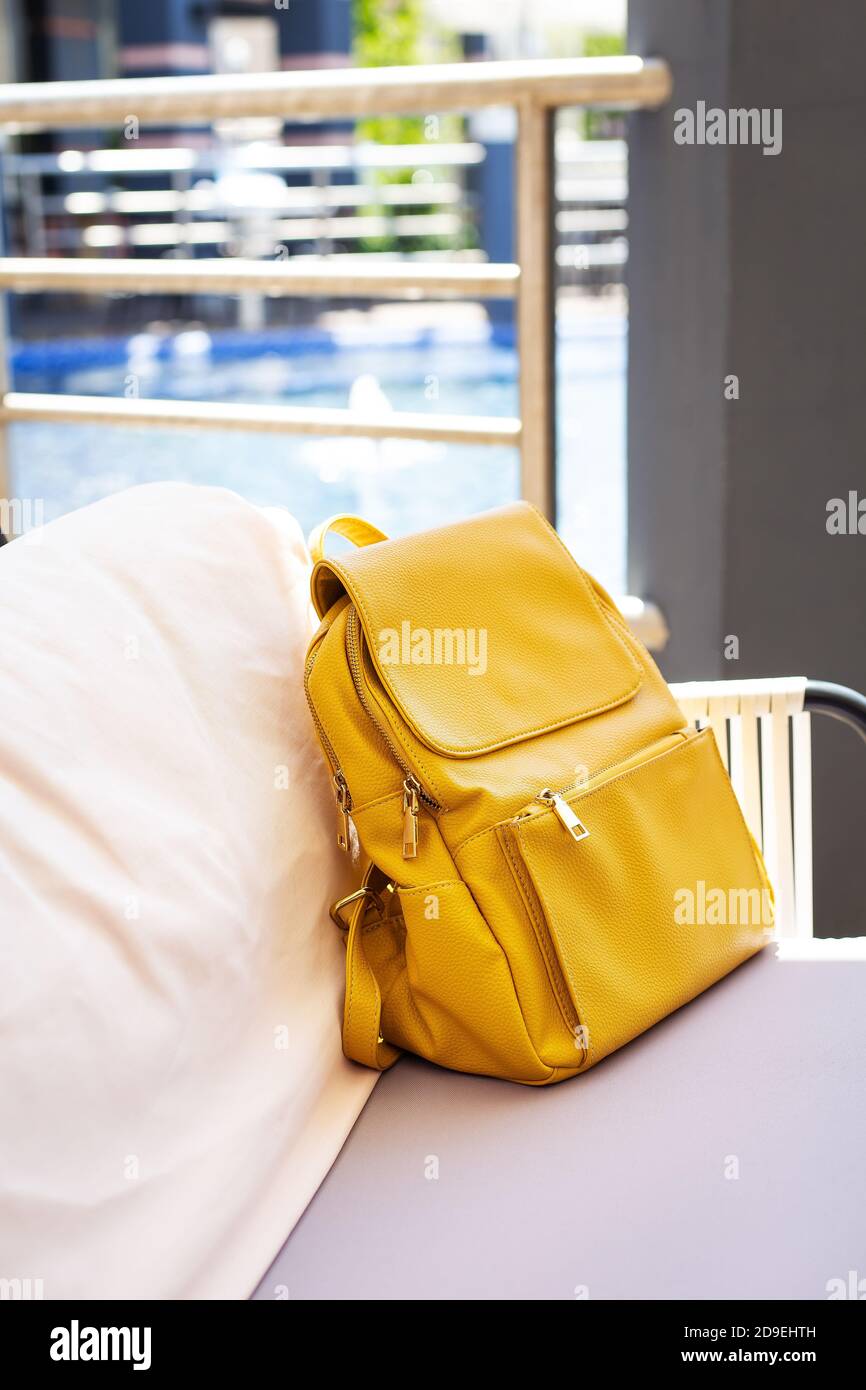 A yellow backpack sits on a soft sofa. Rest from study in a cafe, a ...