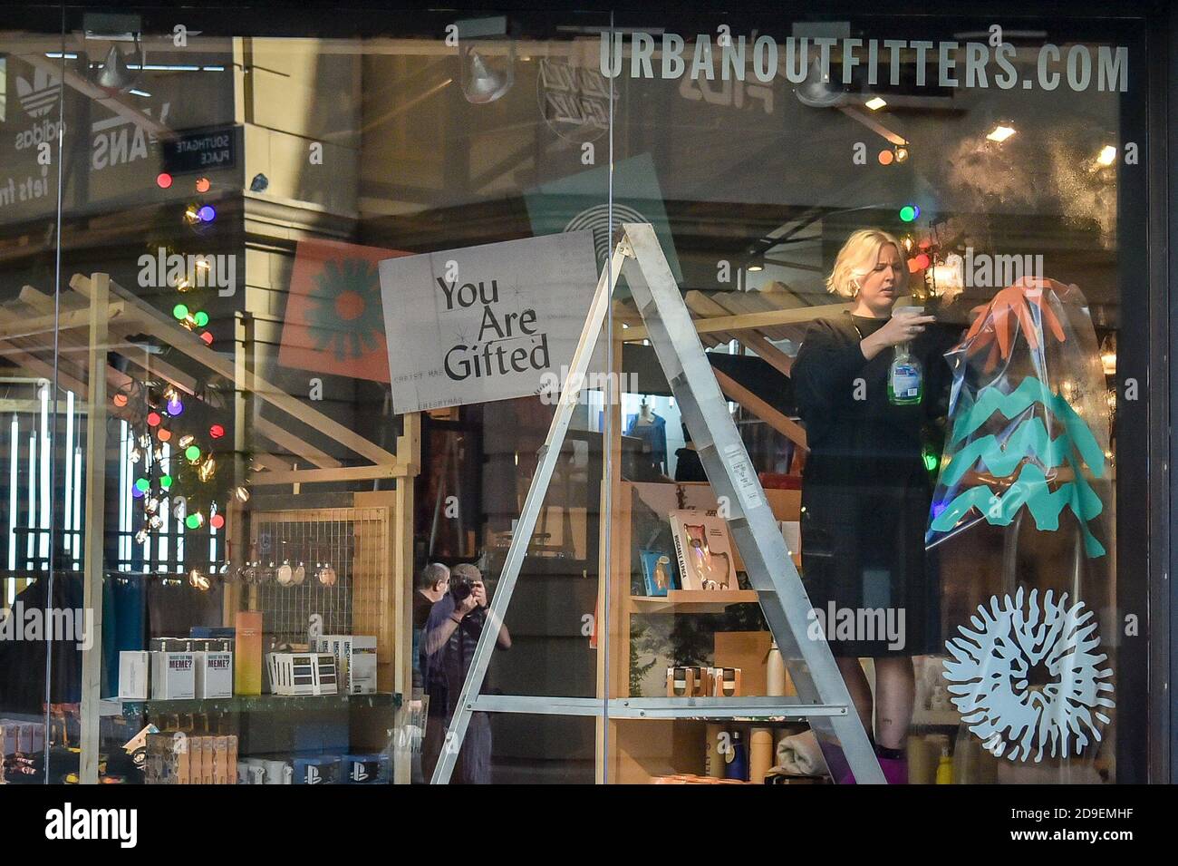 Shop staff arrange window displays while remaining closed to shoppers ...