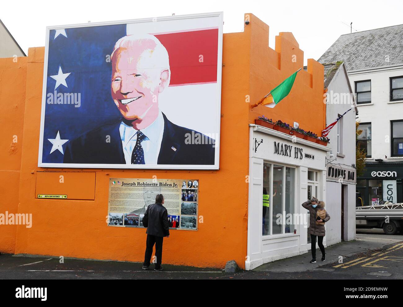 A man stops to read a plaque below a mural of US Presidential candidate ...