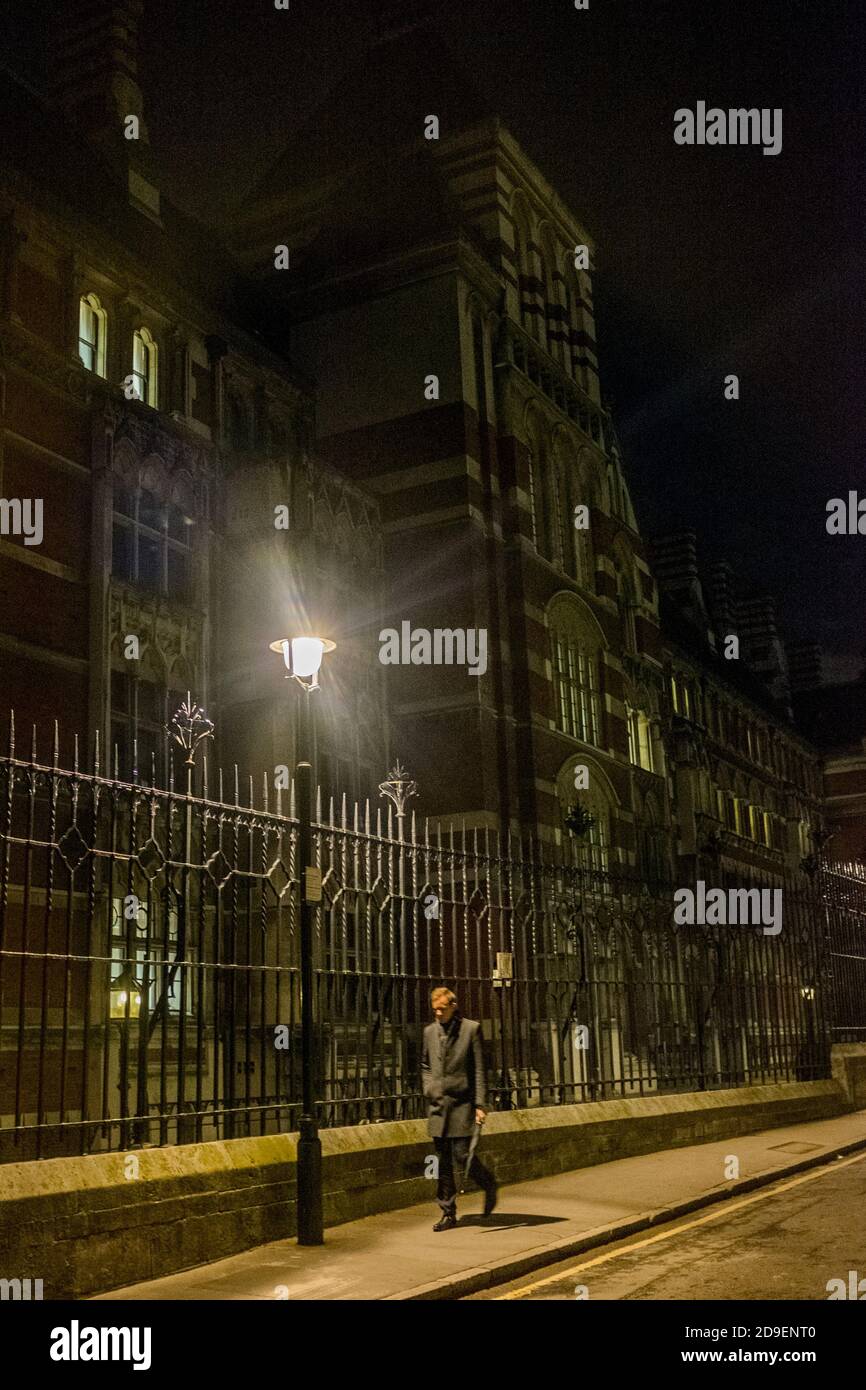 Pedestrian walks along Bell Yard down the east side of the Royal Courts ...