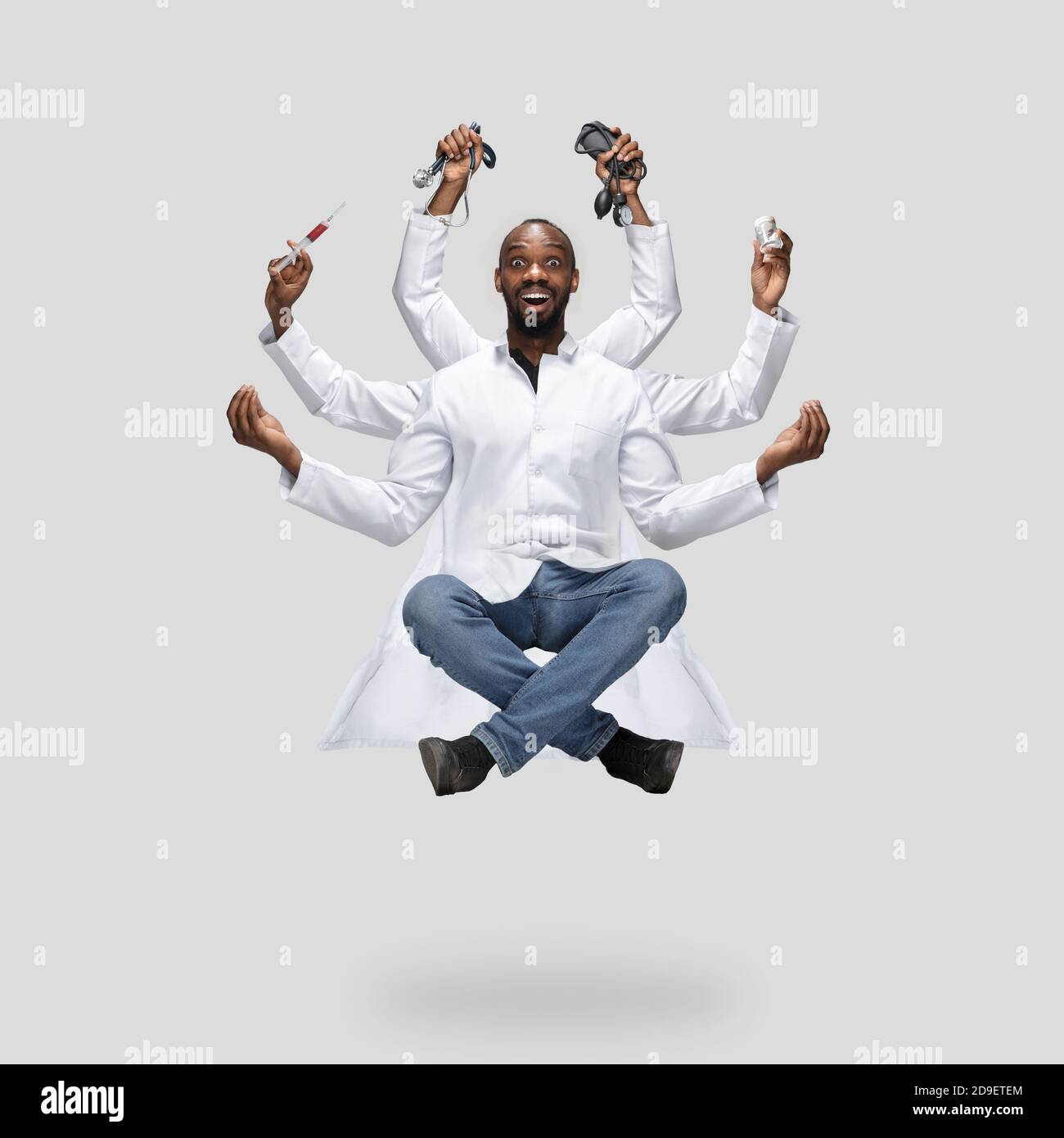 Handsome african doctor, multi-armed man levitating isolated on grey ...