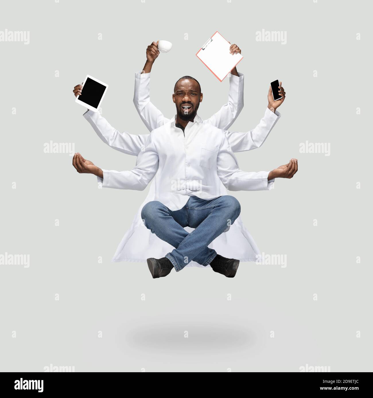 Handsome african doctor, multi-armed man levitating isolated on grey ...
