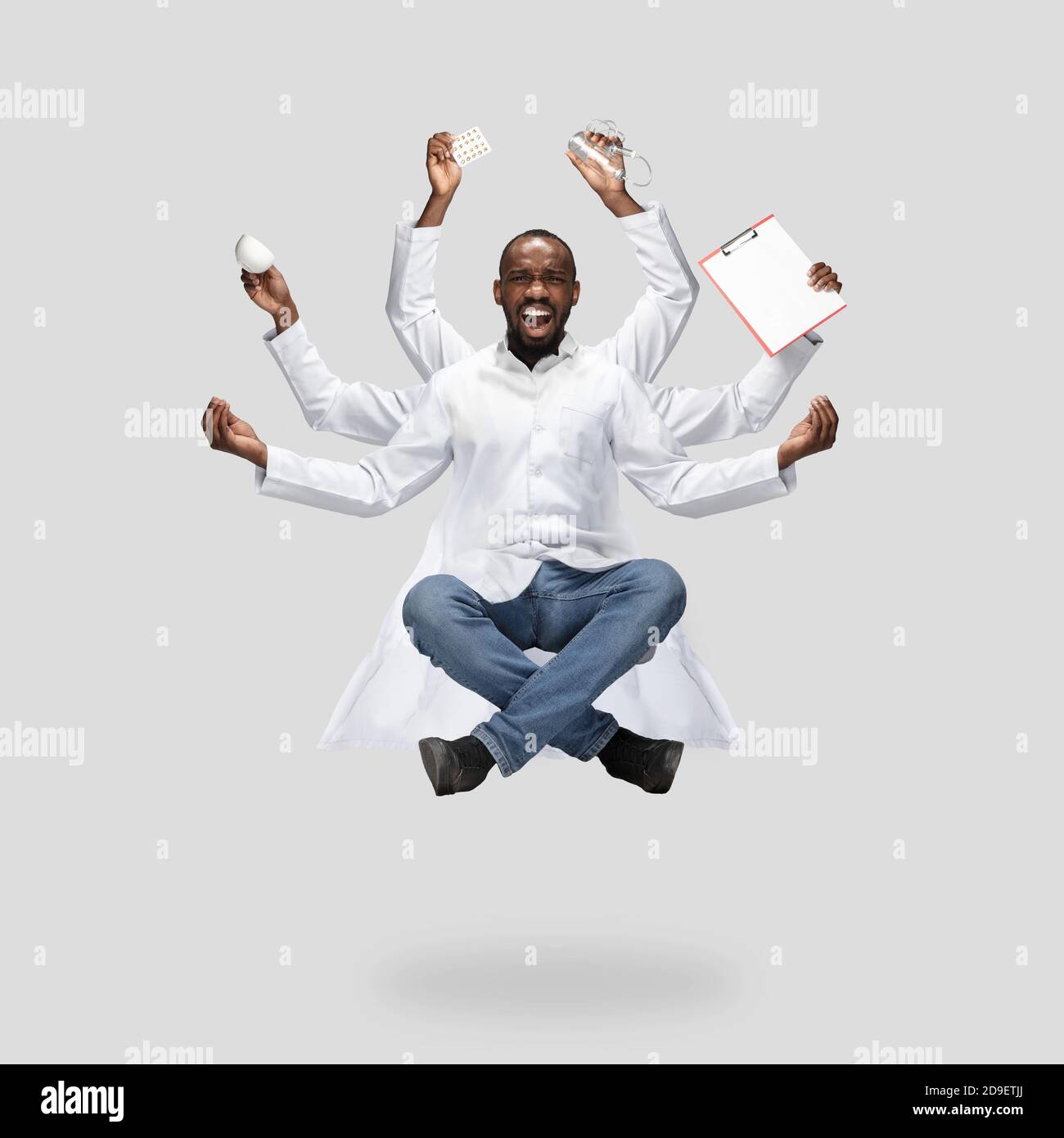Handsome african doctor, multi-armed man levitating isolated on grey ...