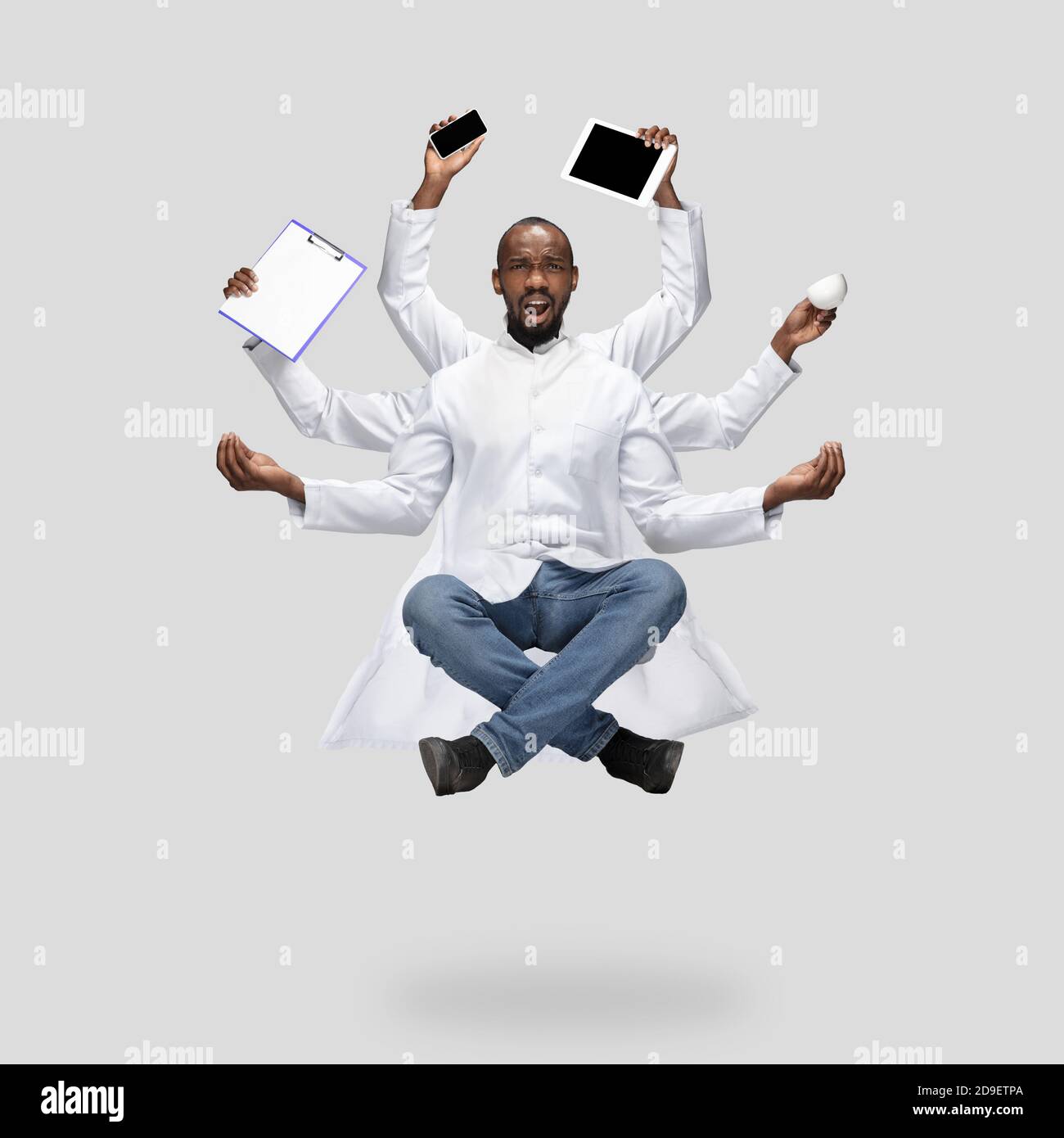Handsome african doctor, multi-armed man levitating isolated on grey ...
