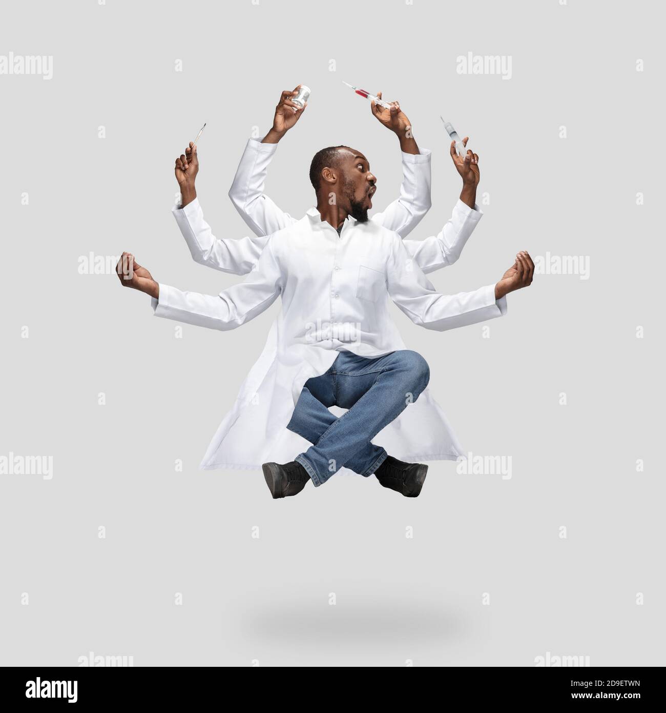 Handsome african doctor, multi-armed man levitating isolated on grey ...