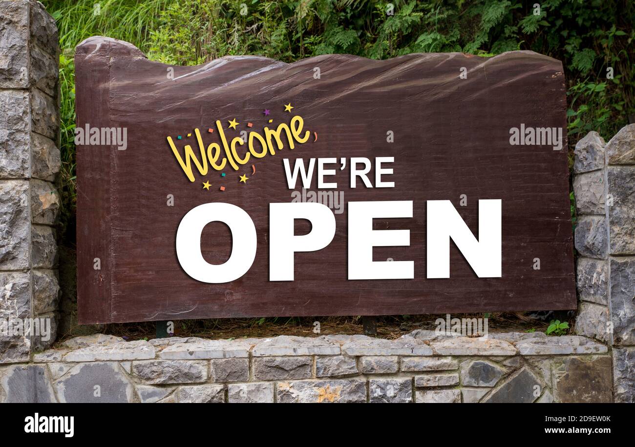 Welcome back we are open wood sign outside a shop Stock Photo - Alamy
