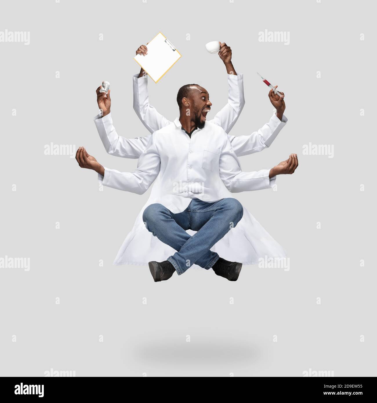 Handsome african doctor, multi-armed man levitating isolated on grey ...