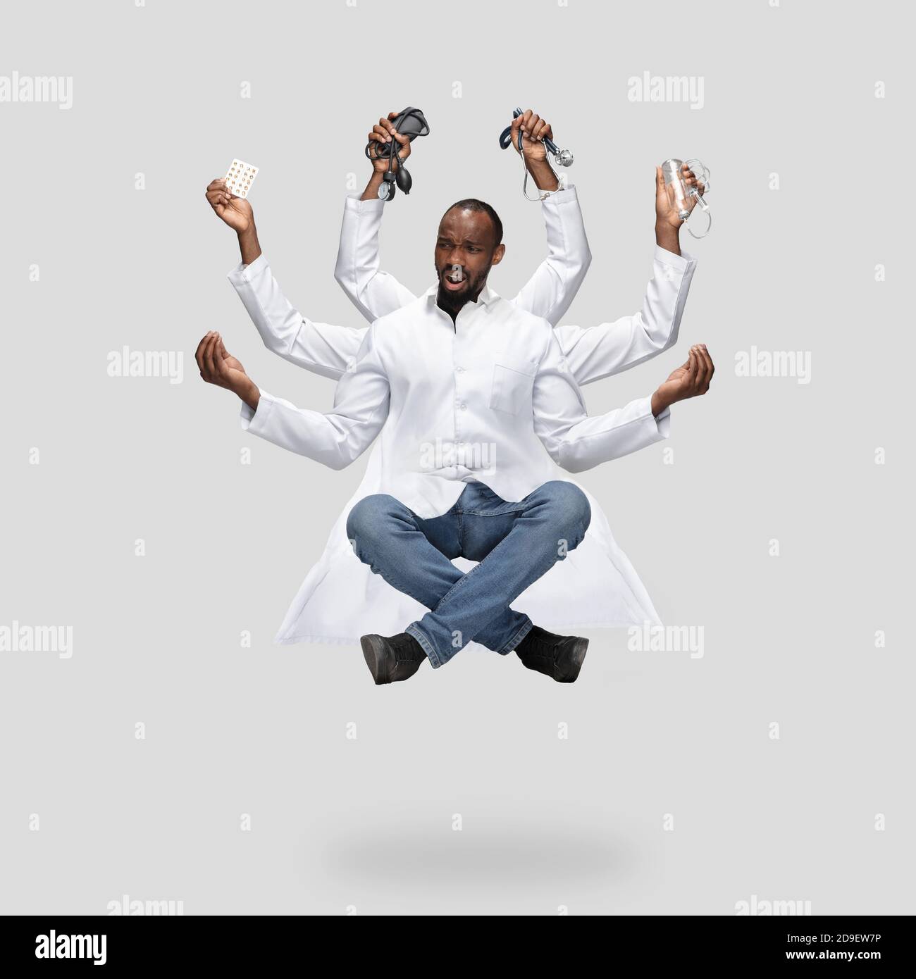Handsome african doctor, multi-armed man levitating isolated on grey ...