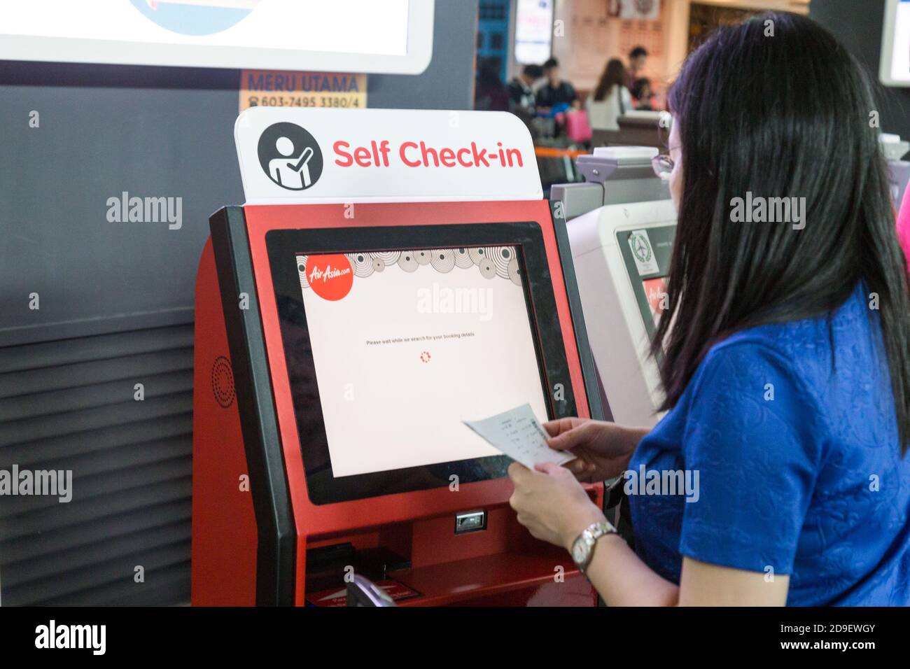 Passenger using convenient self check-in kiosk machine at KL ...
