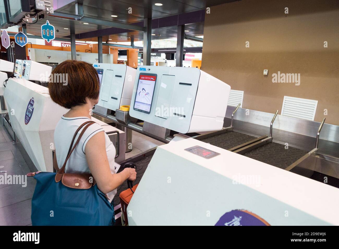 Passenger using convenient self check-in luggage bag machine at KL ...