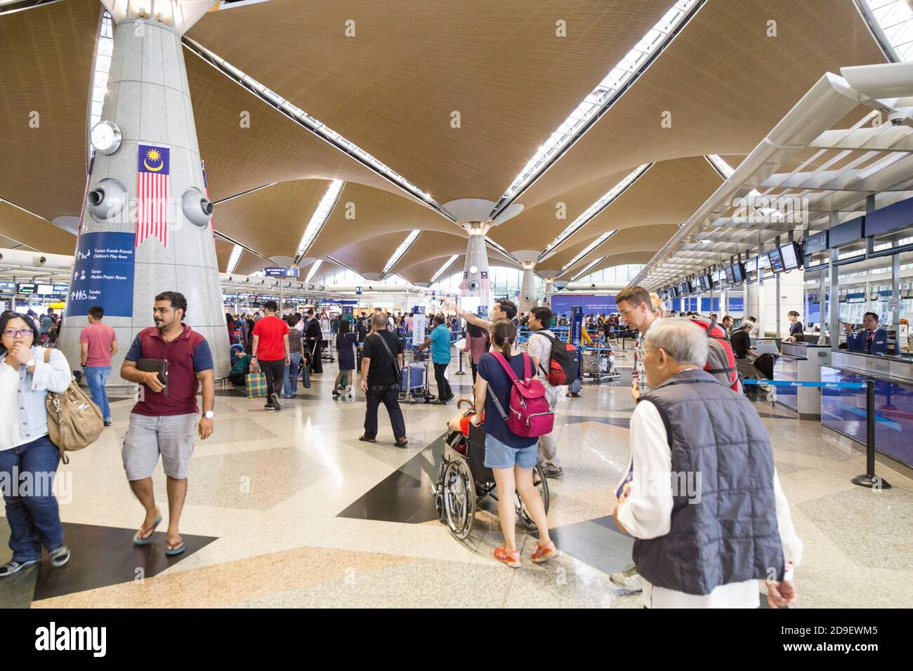 Travelers walking around identifying their flights check-in counters at ...