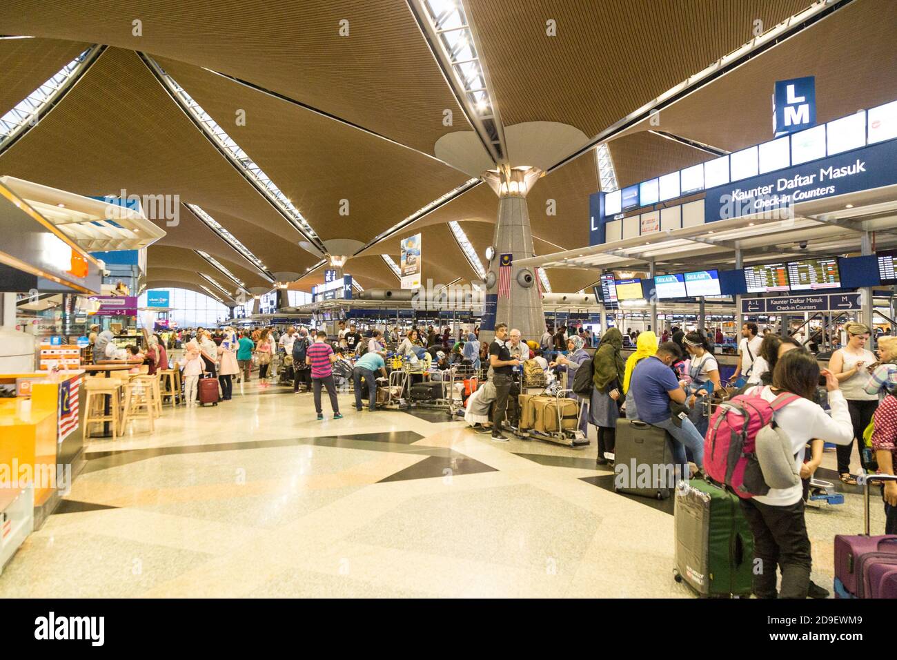 Travelers walking around identifying their flights check-in counters at ...