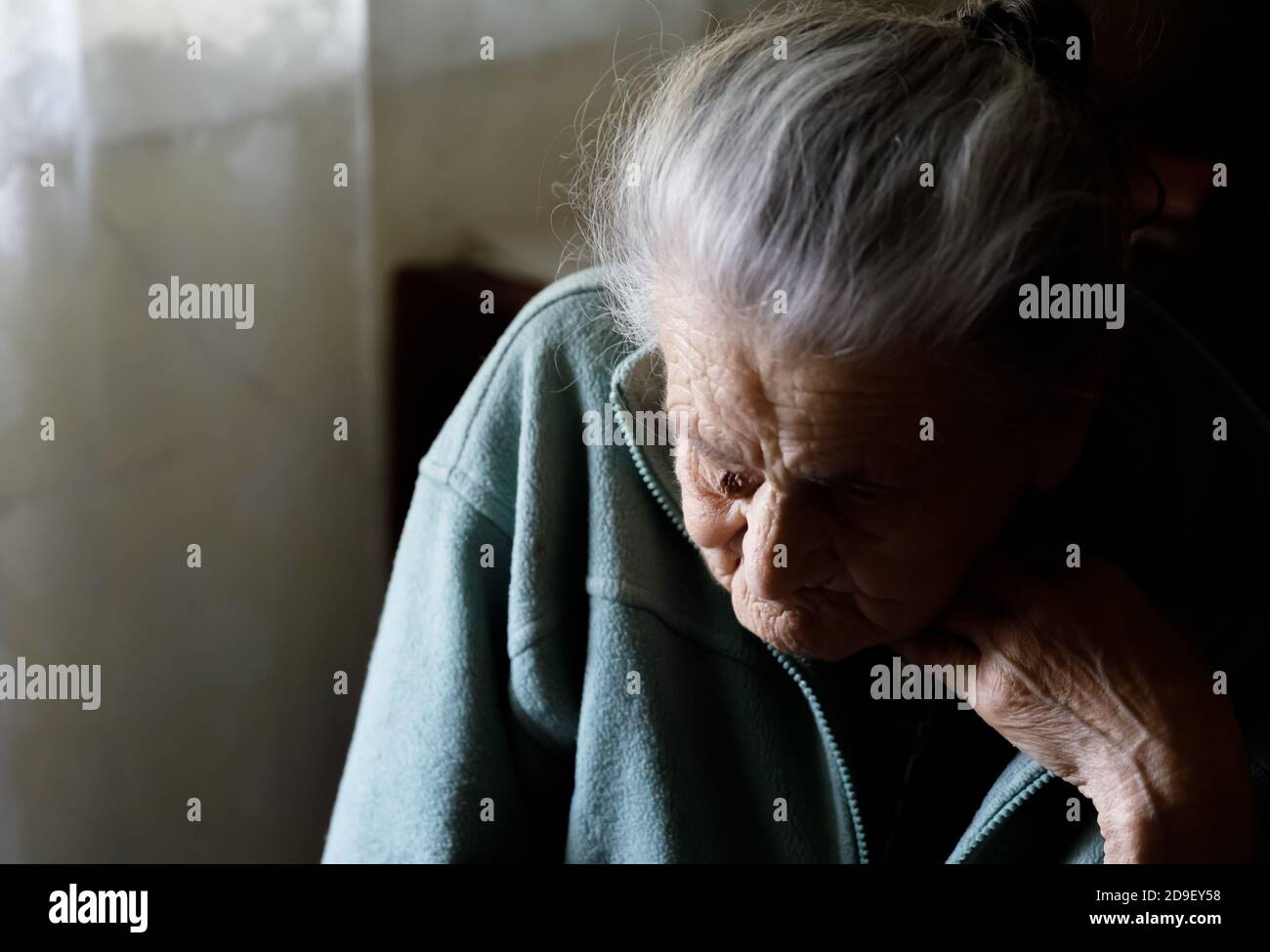Portrait of a very old tired woman sitting near a window Stock Photo ...