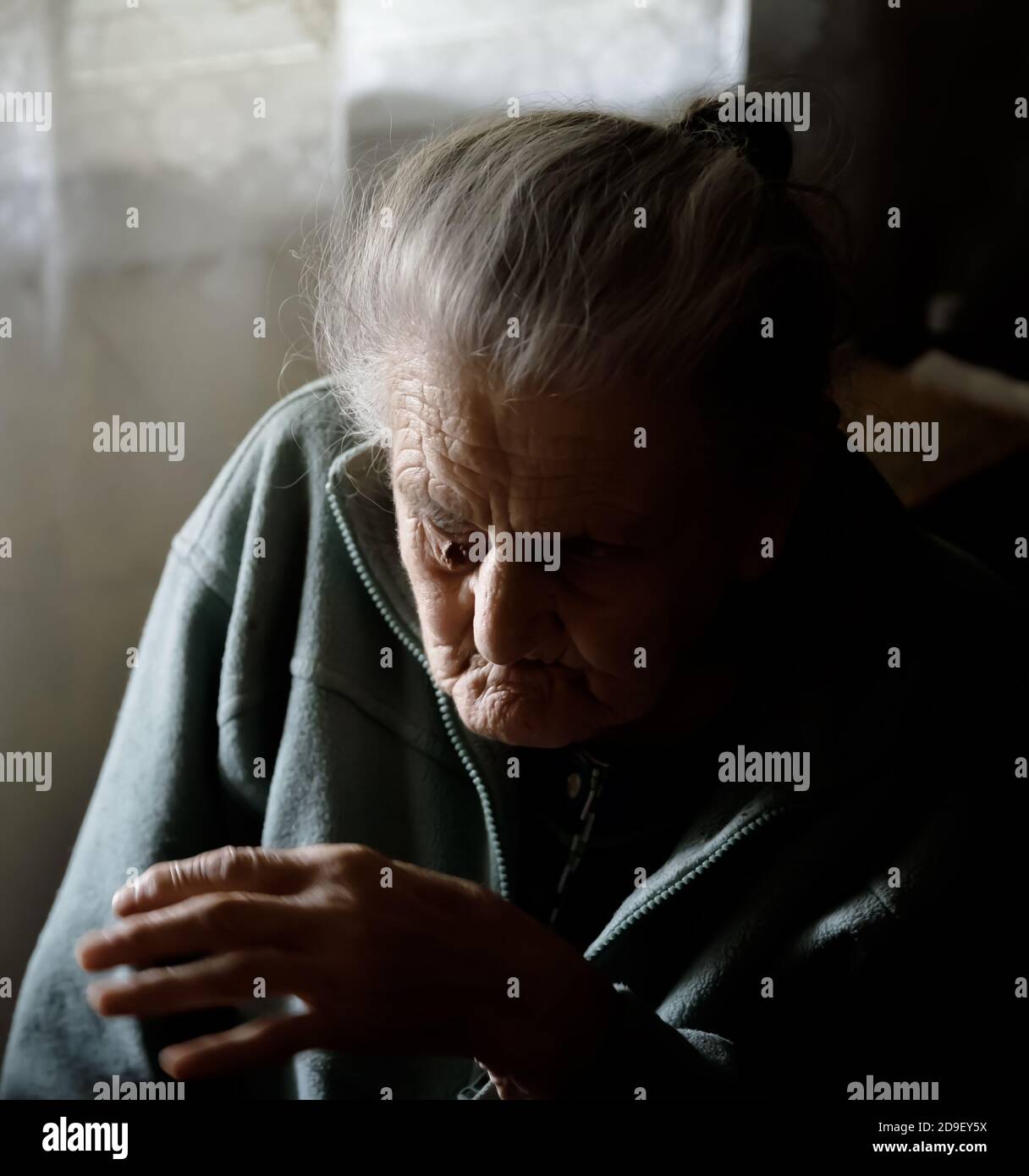 Portrait of a very old tired woman sitting near a window Stock Photo ...