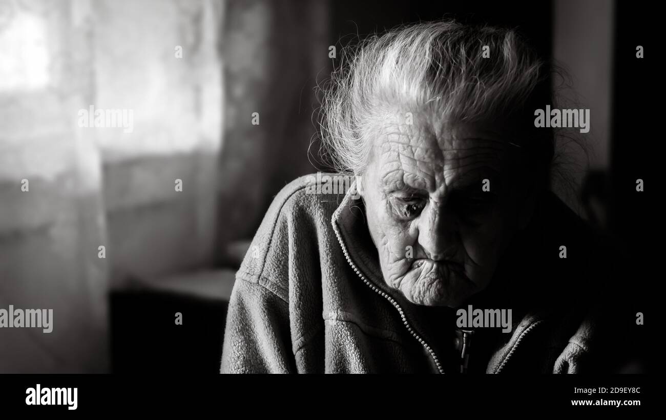 Black and white portrait of a very old tired woman sitting near the ...