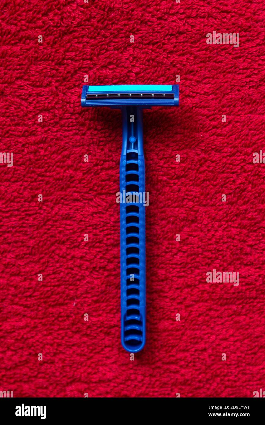 The blue razor lies on the red cloth. Deep texture Stock Photo - Alamy