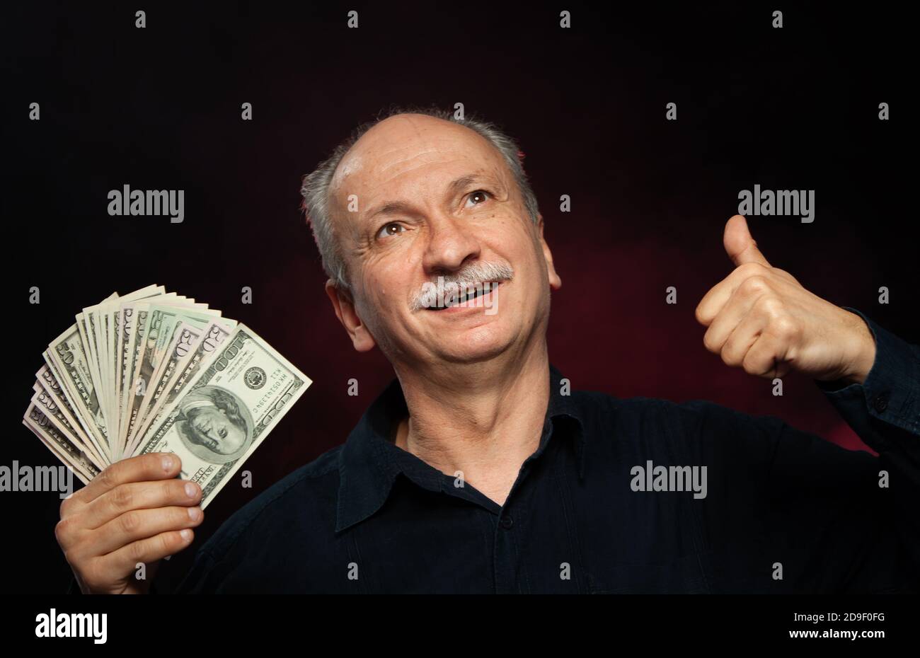 Senior gentleman holding a stack of money. Portrait of an excited old ...