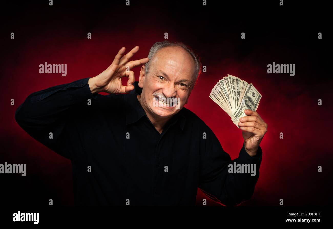 Senior gentleman holding a stack of money. Portrait of an excited old ...